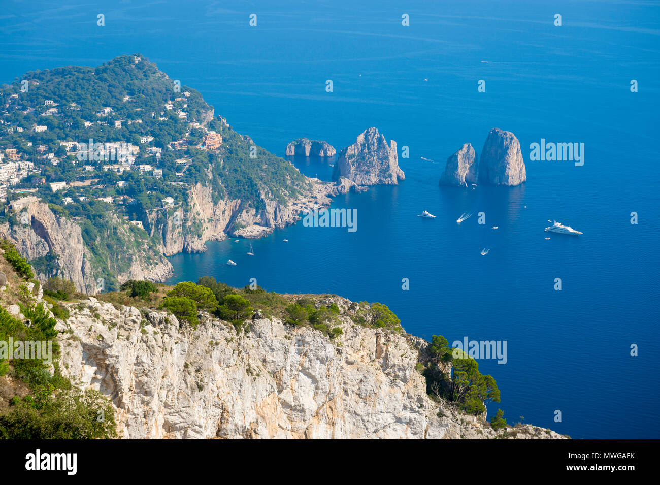 Bright scenic view of the iconic Faraglioni rocks from the cliffside ...