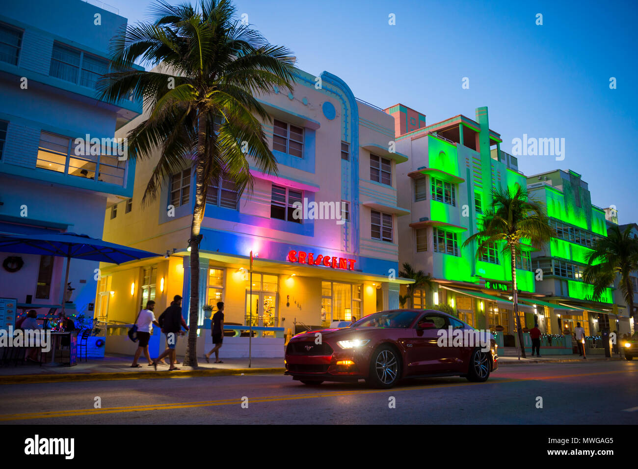 MIAMI - JANUARY 08, 2018: A red convertible drives past iconic art deco ...