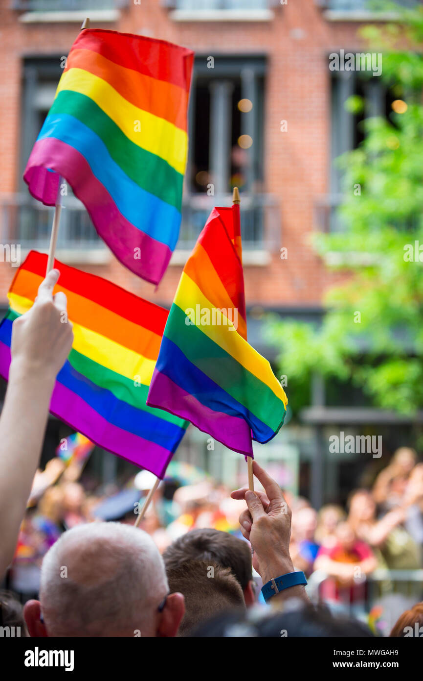 Rainbow flags flying in bright sun on the sidelines of a colorful ...