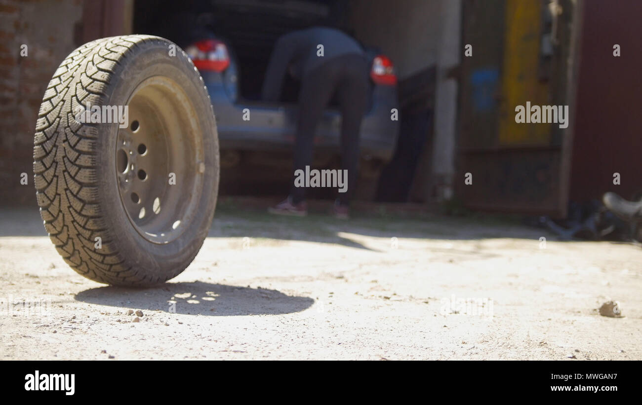 Car wheels rolling on the ground in front of car garage Stock Photo - Alamy