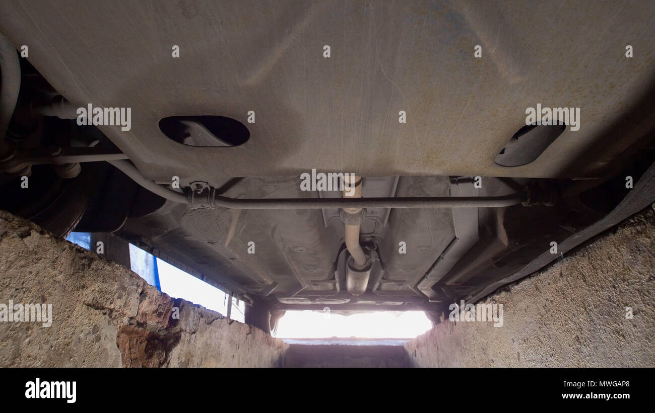 The bottom of car in the inspection pit in garage Stock Photo - Alamy
