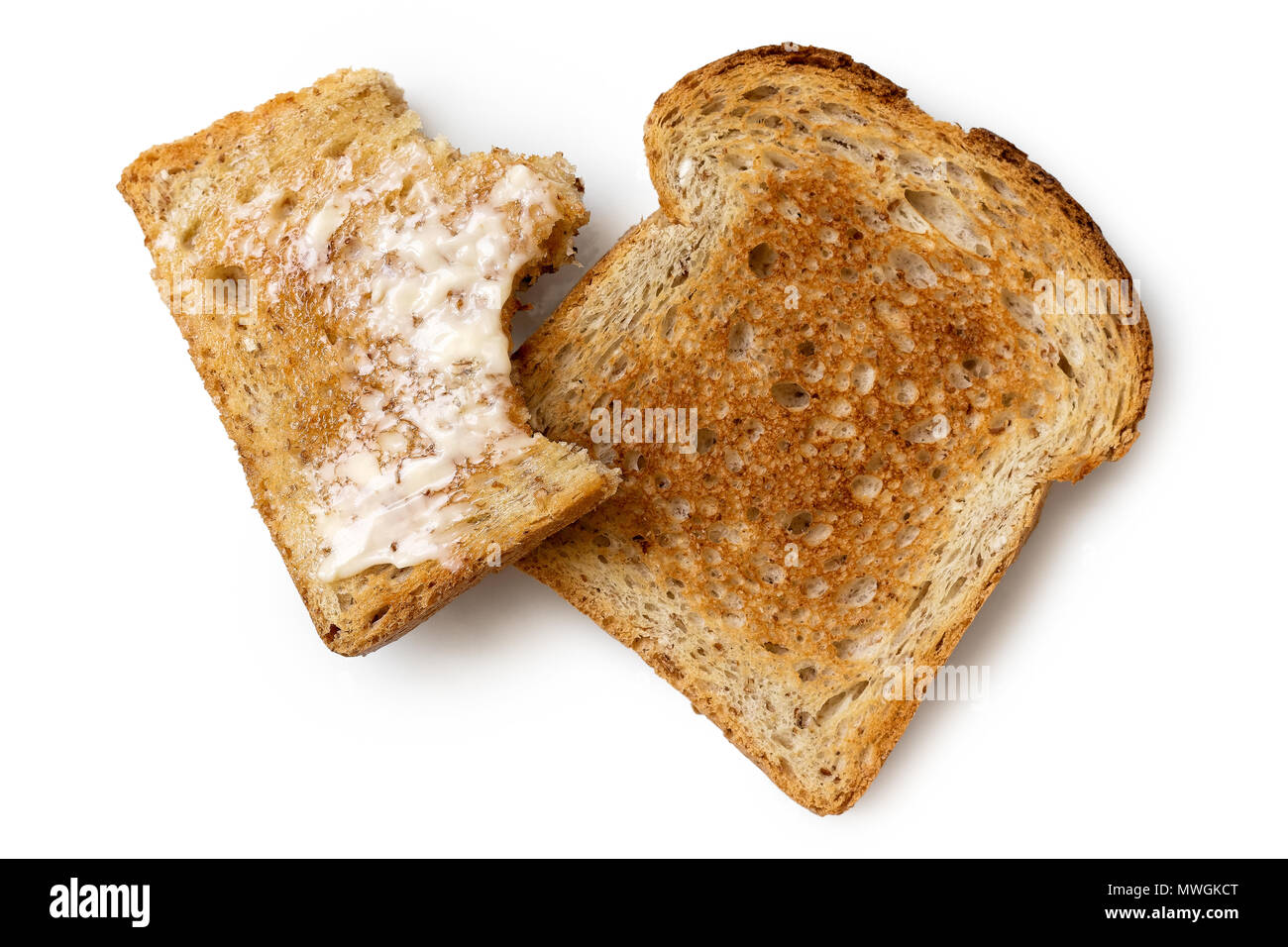Half eaten buttered slice of whole wheat toast and whole dry slice of ...