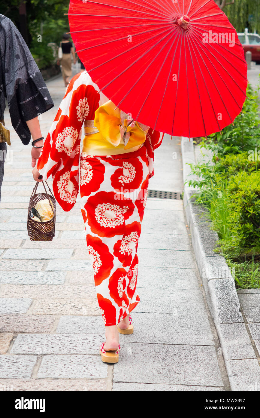 A woman walking down a Kyoto Street in Japan with traditional Geta ...