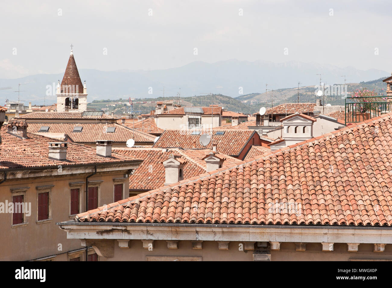 Terracotta tiled roof tops in Italy with far reaching hills in the ...