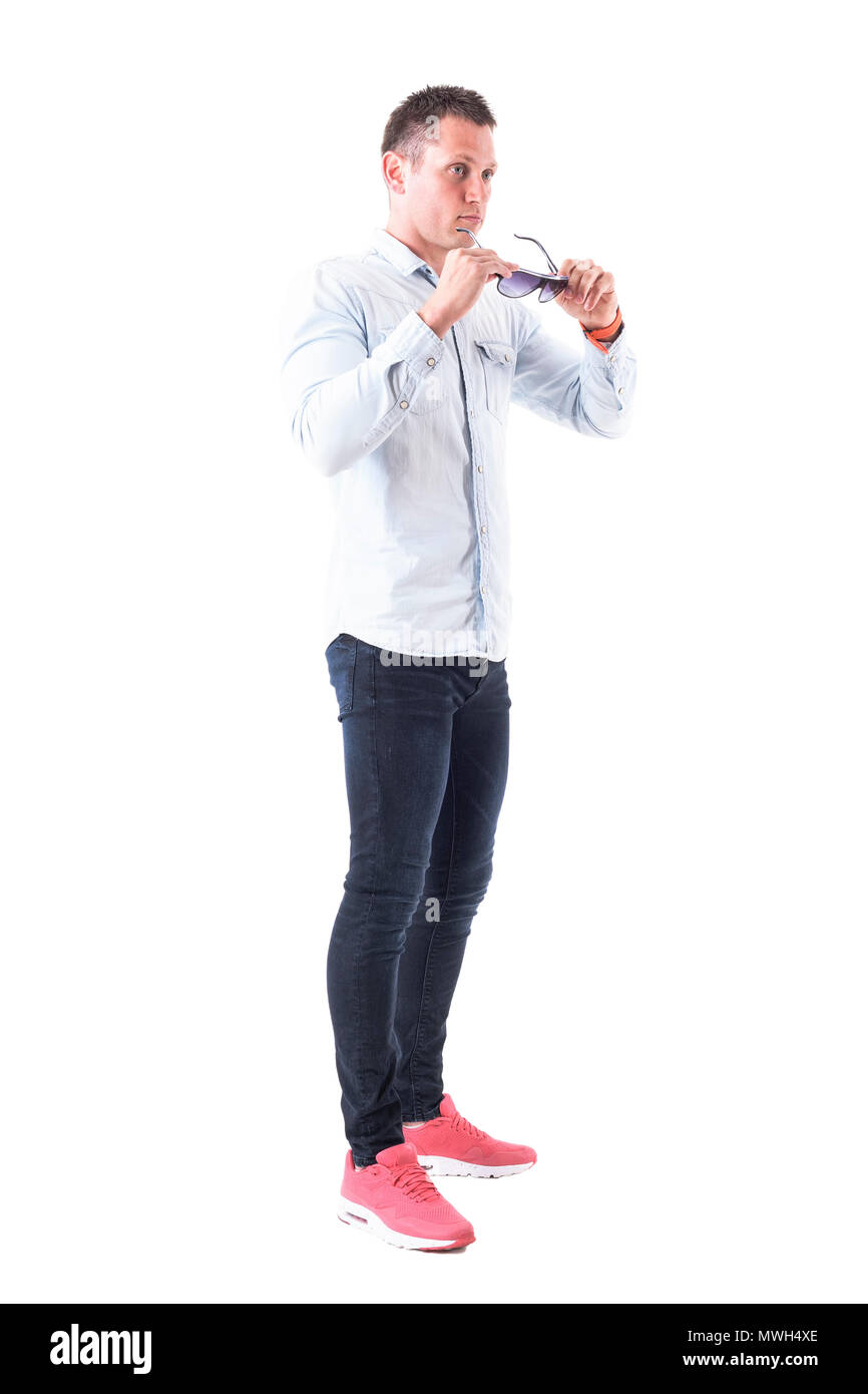 Handsome confident young adult man removing sunglasses looking away ...