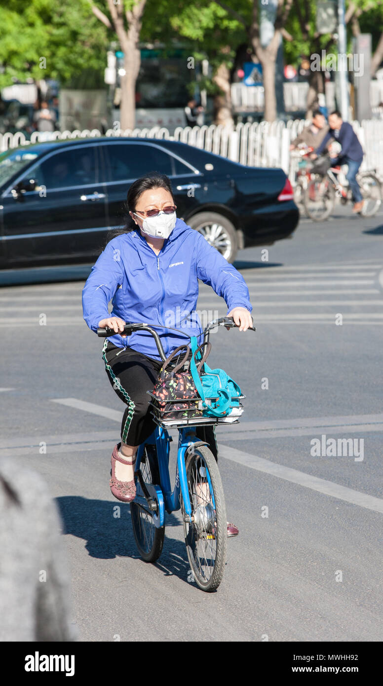 Woman,cycling,while,wearing,air,pollution,face,mask,masks,in,centre,of ...
