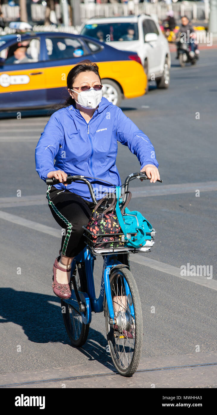 Woman,cycling,while,wearing,air,pollution,face,mask,masks,in,centre,of ...
