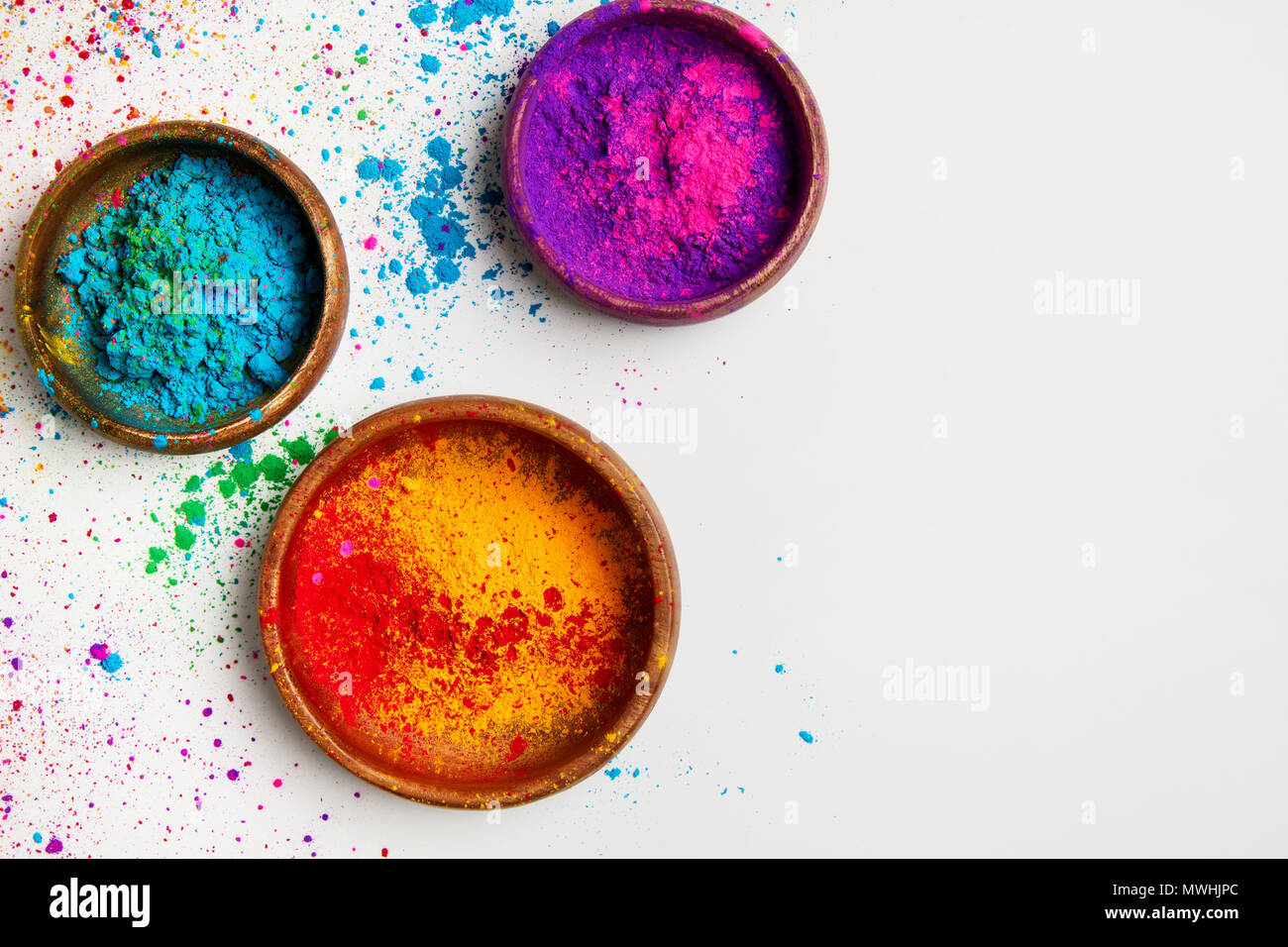 top view of colorful traditional holi powder in bowls isolated on white ...