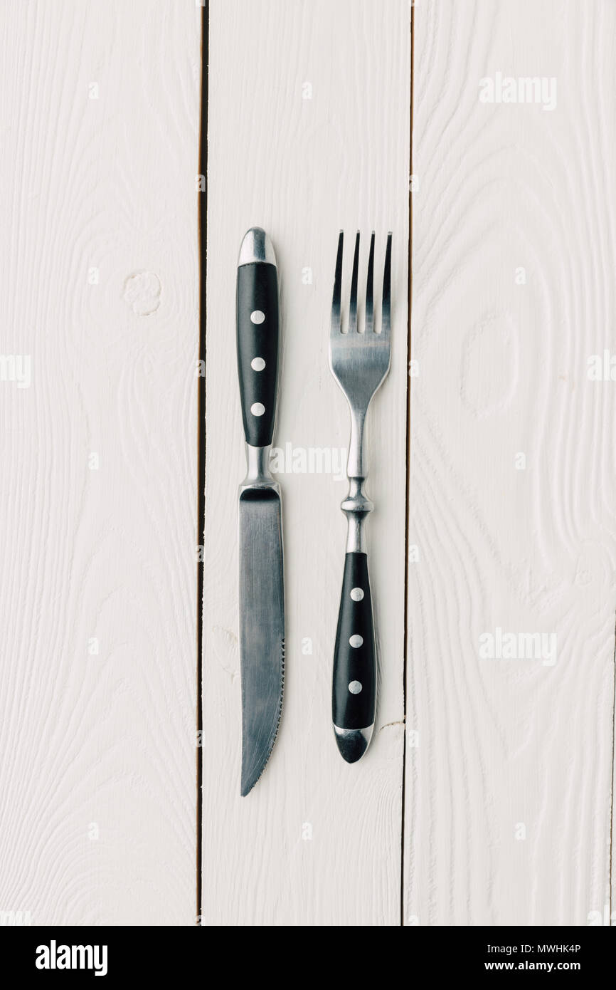 top view of modern cutlery set on white wooden background Stock Photo ...