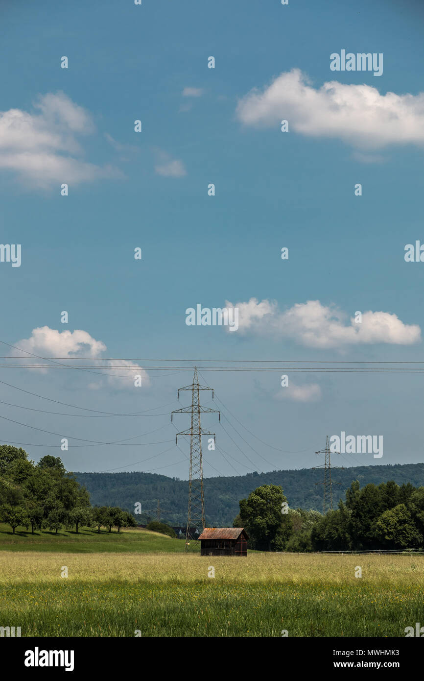 Power pylon in the German countryside with forests, fields and meadows ...
