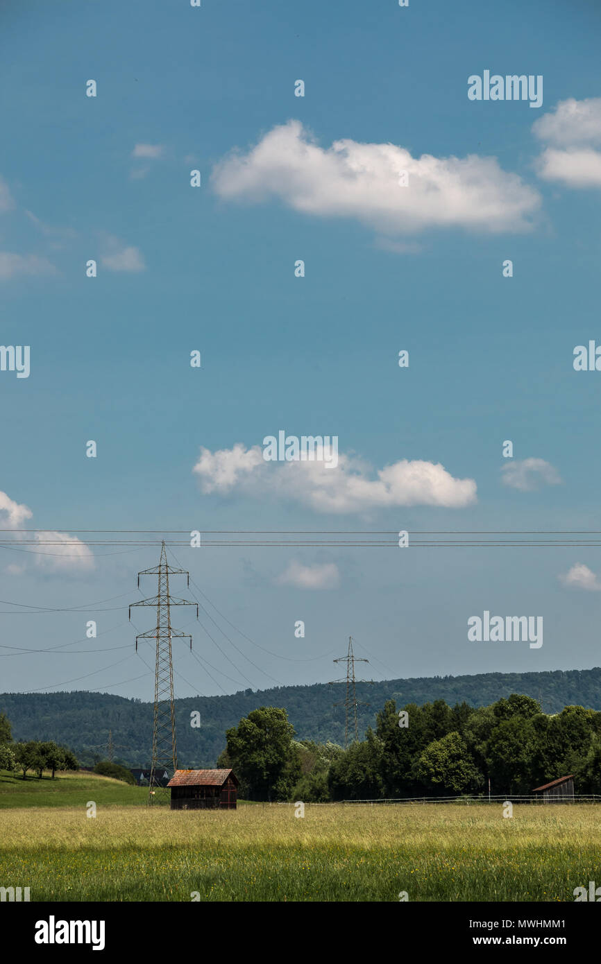 Power pylon in the German countryside with forests, fields and meadows ...
