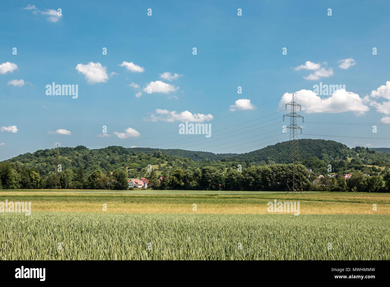 Power pylon in the German countryside with forests, fields and meadows ...