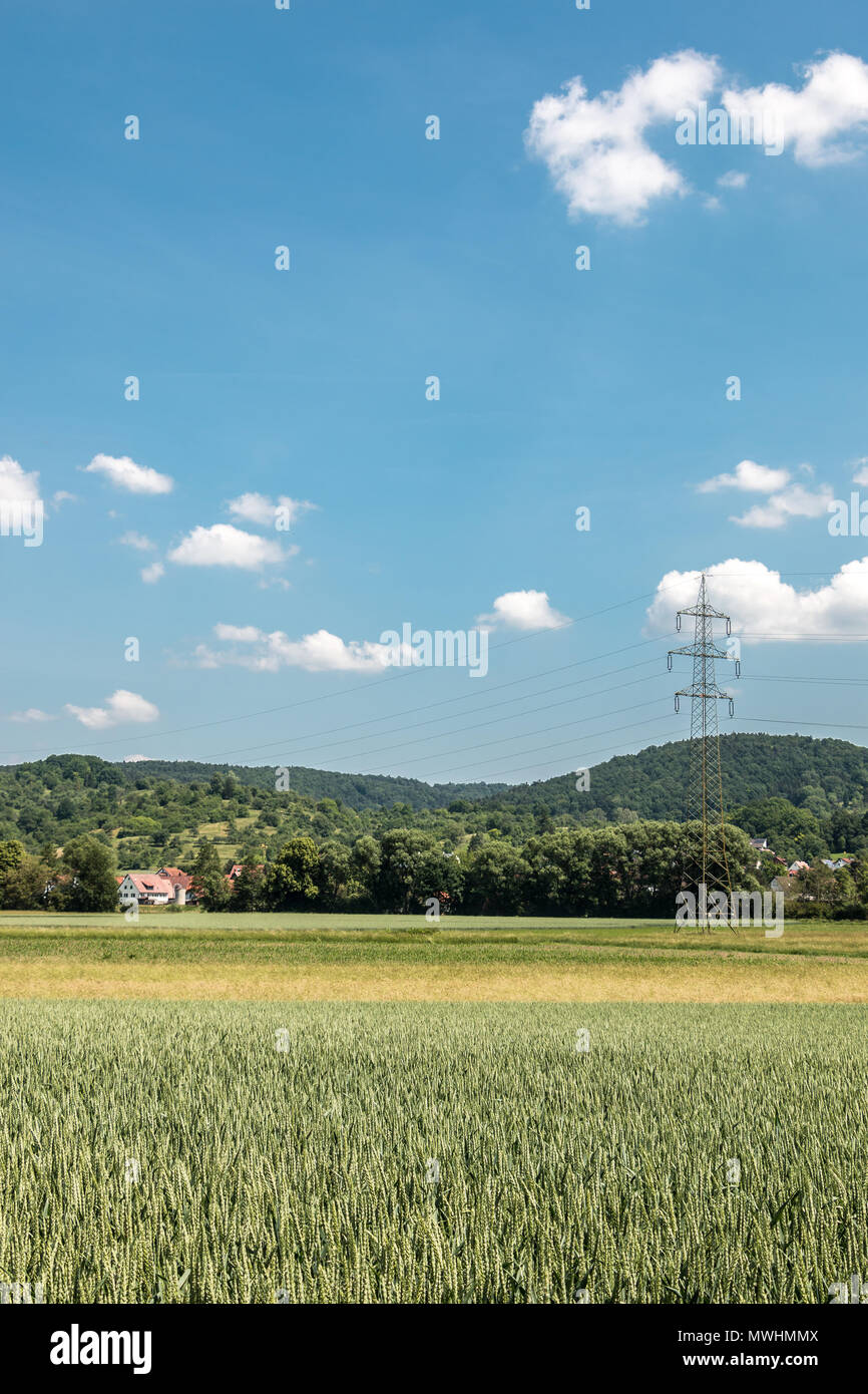 Power pylon in the German countryside with forests, fields and meadows ...