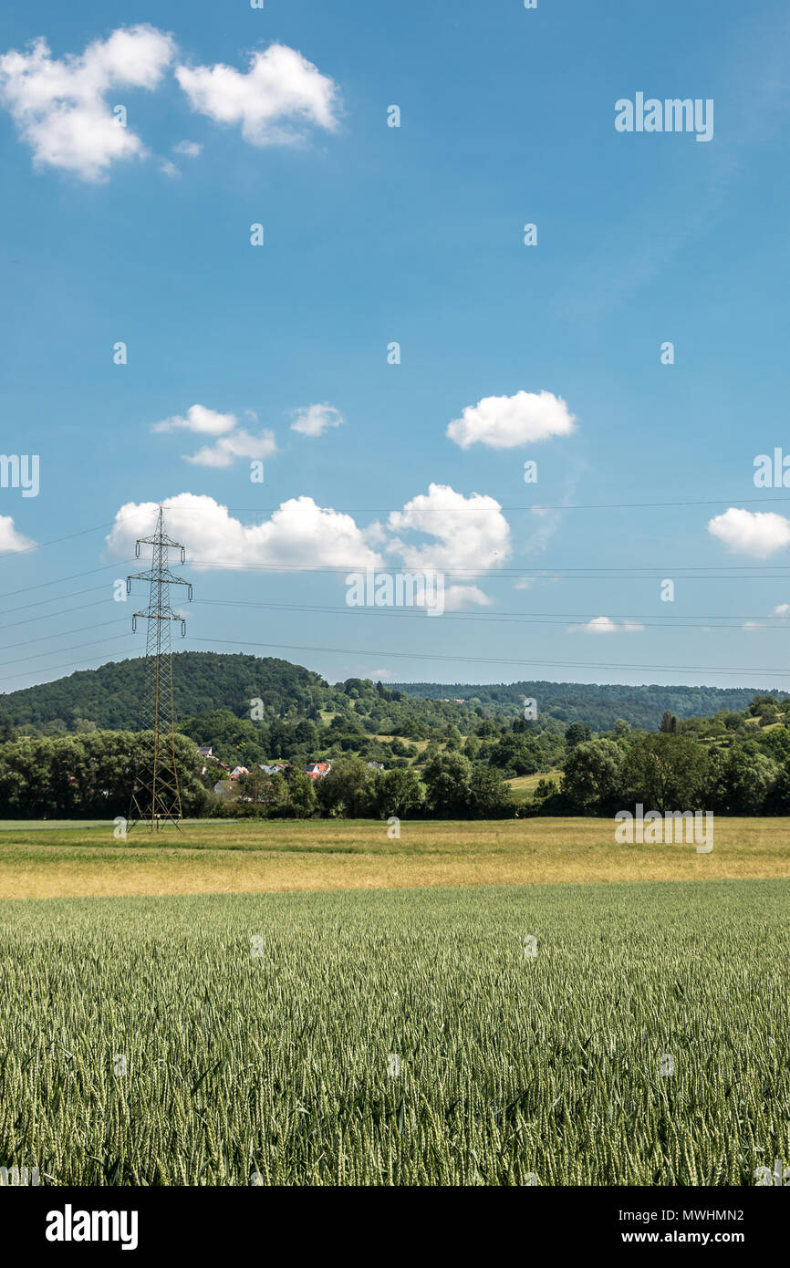 Power pylon in the German countryside with forests, fields and meadows ...