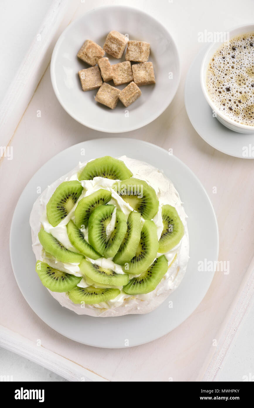 Pavlova meringue cake with kiwi slices and whipped cream. Top view ...