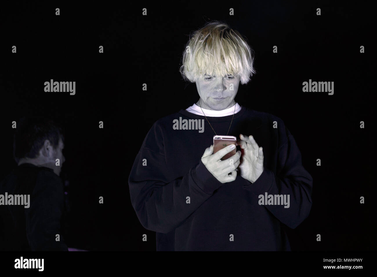 Tim Burgess, lead singer of The Charlatans, using his phone during a ...