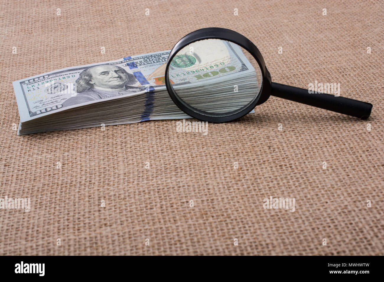 Magnifying glass over the banknote bundle of US dollar Stock Photo - Alamy