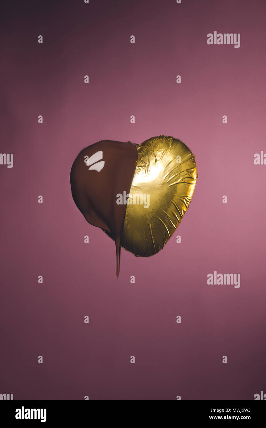 heart shaped candy in golden wrapper with liquid chocolate isolated on ...