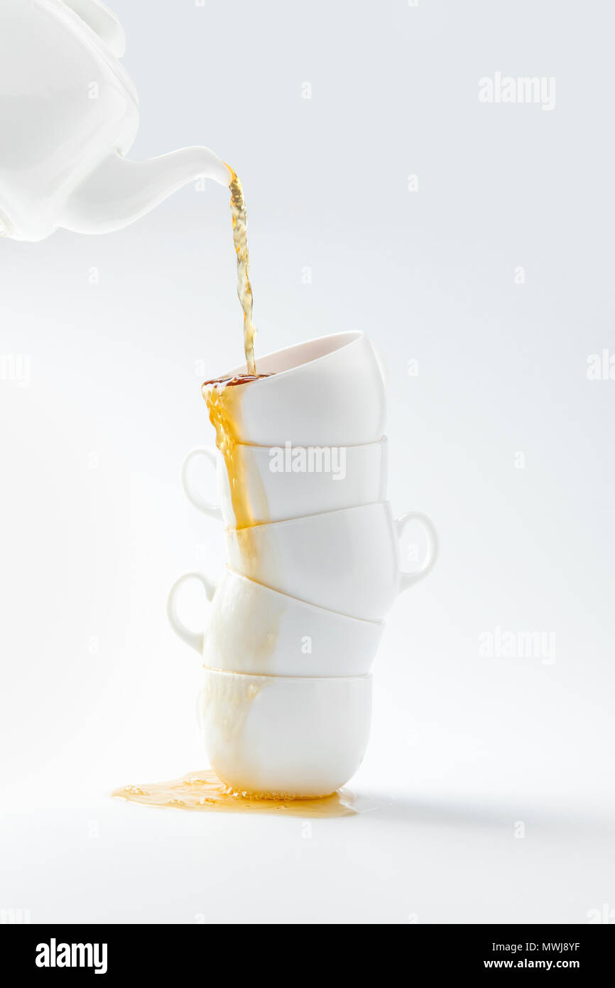 composition of pouring tea from teapot in cups isolated on white Stock ...