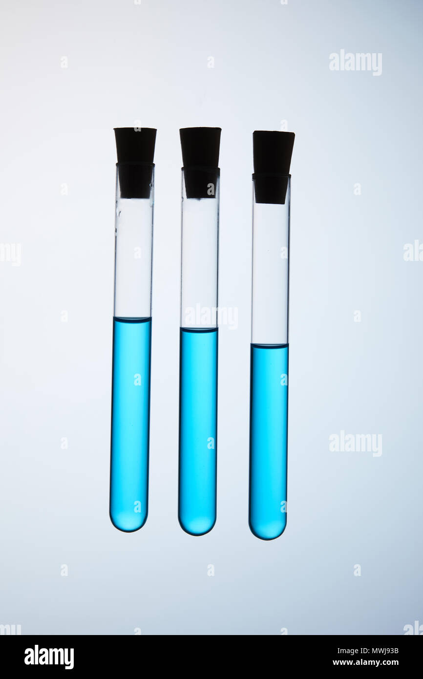 composition of test tubes filled with blue liquid floating in air on ...