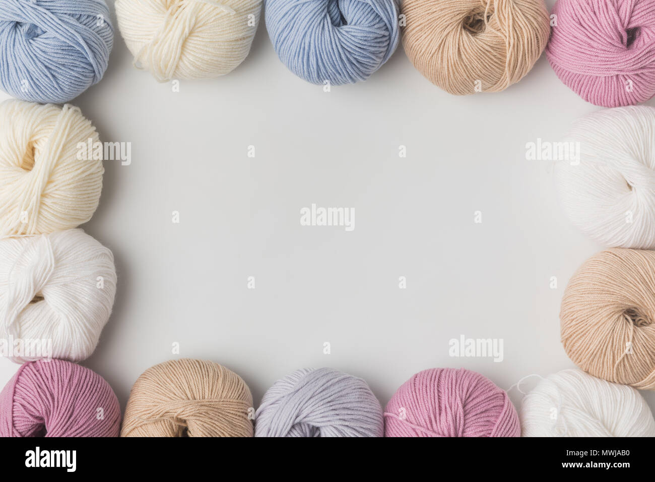 top view of colored yarn balls in a row isolated on white background ...