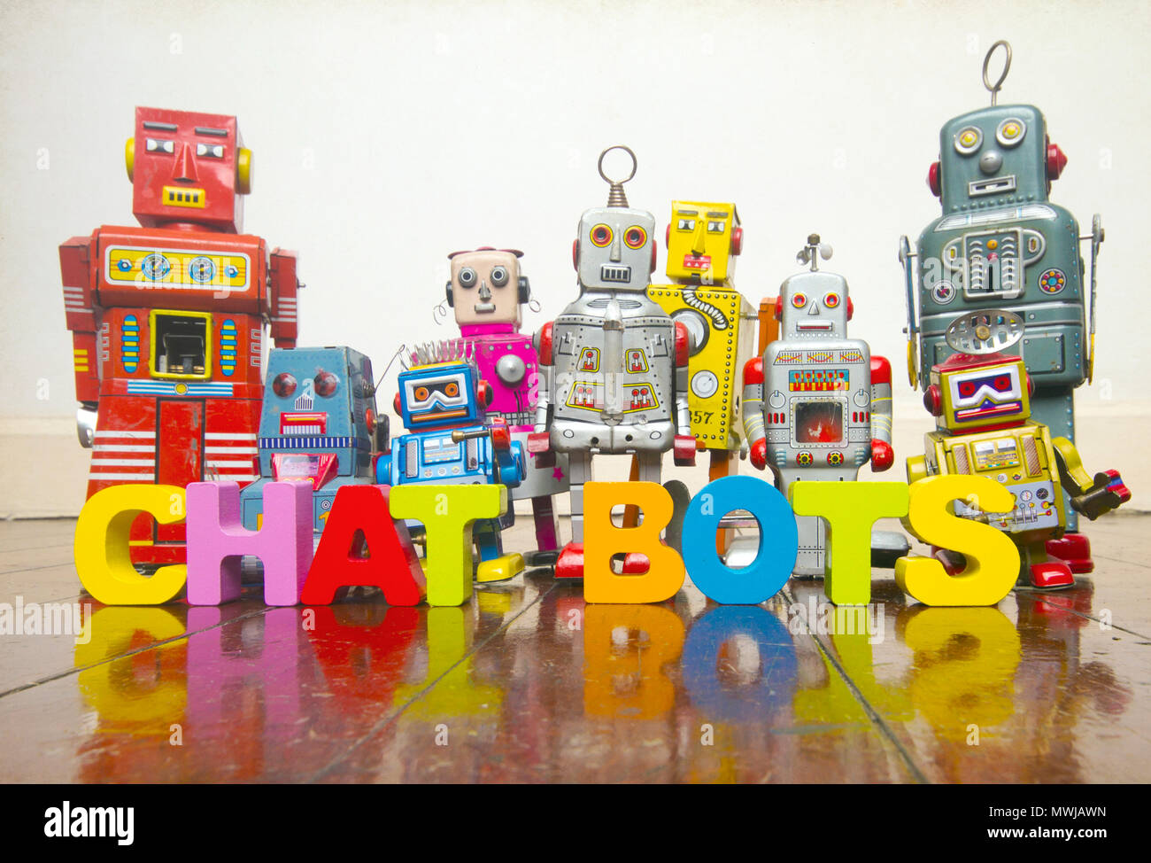 the word A CHAT BOTS with wooden letters and retro toy robots on an old ...