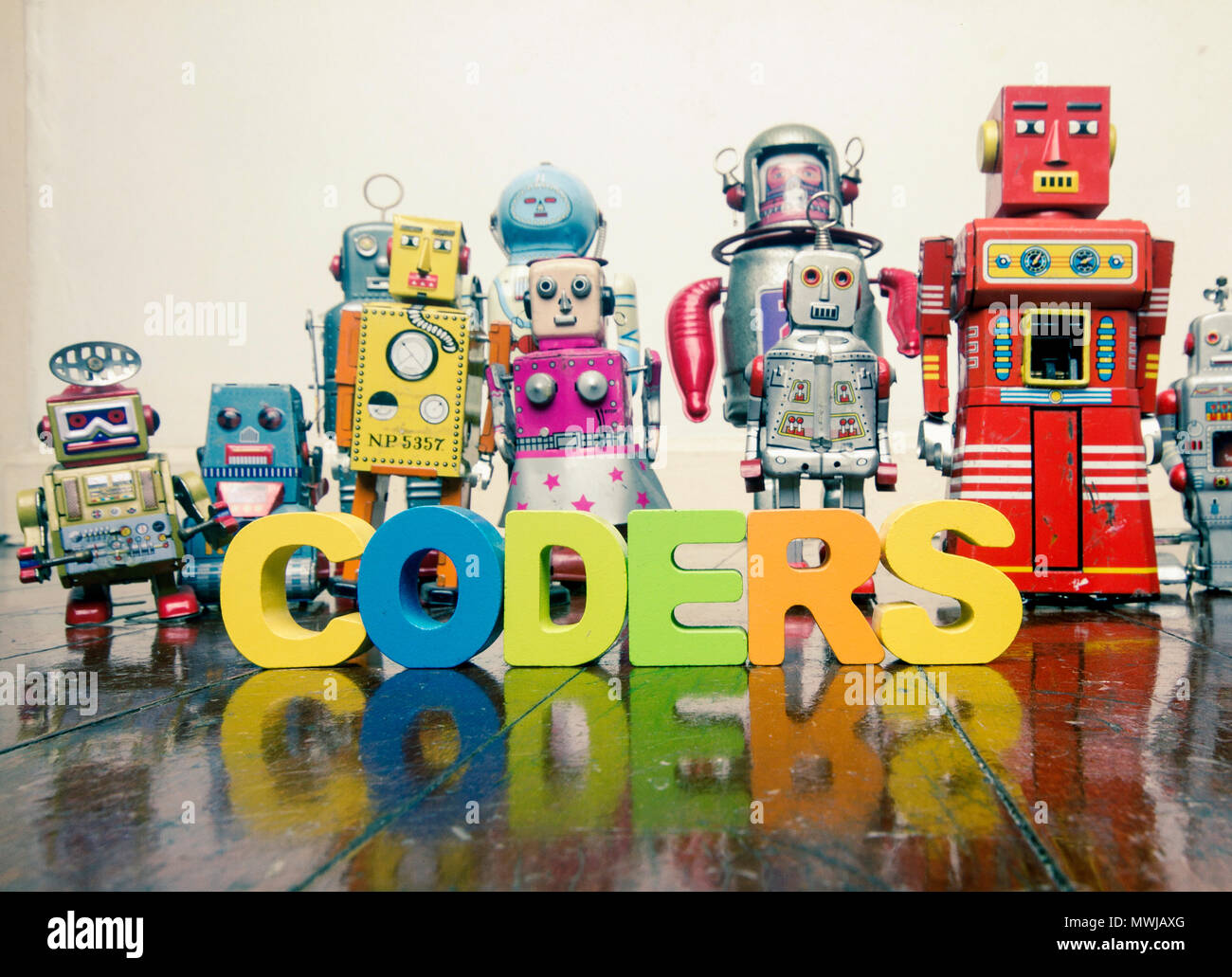the word CODERS with wooden letters and retro toy robots on an old ...