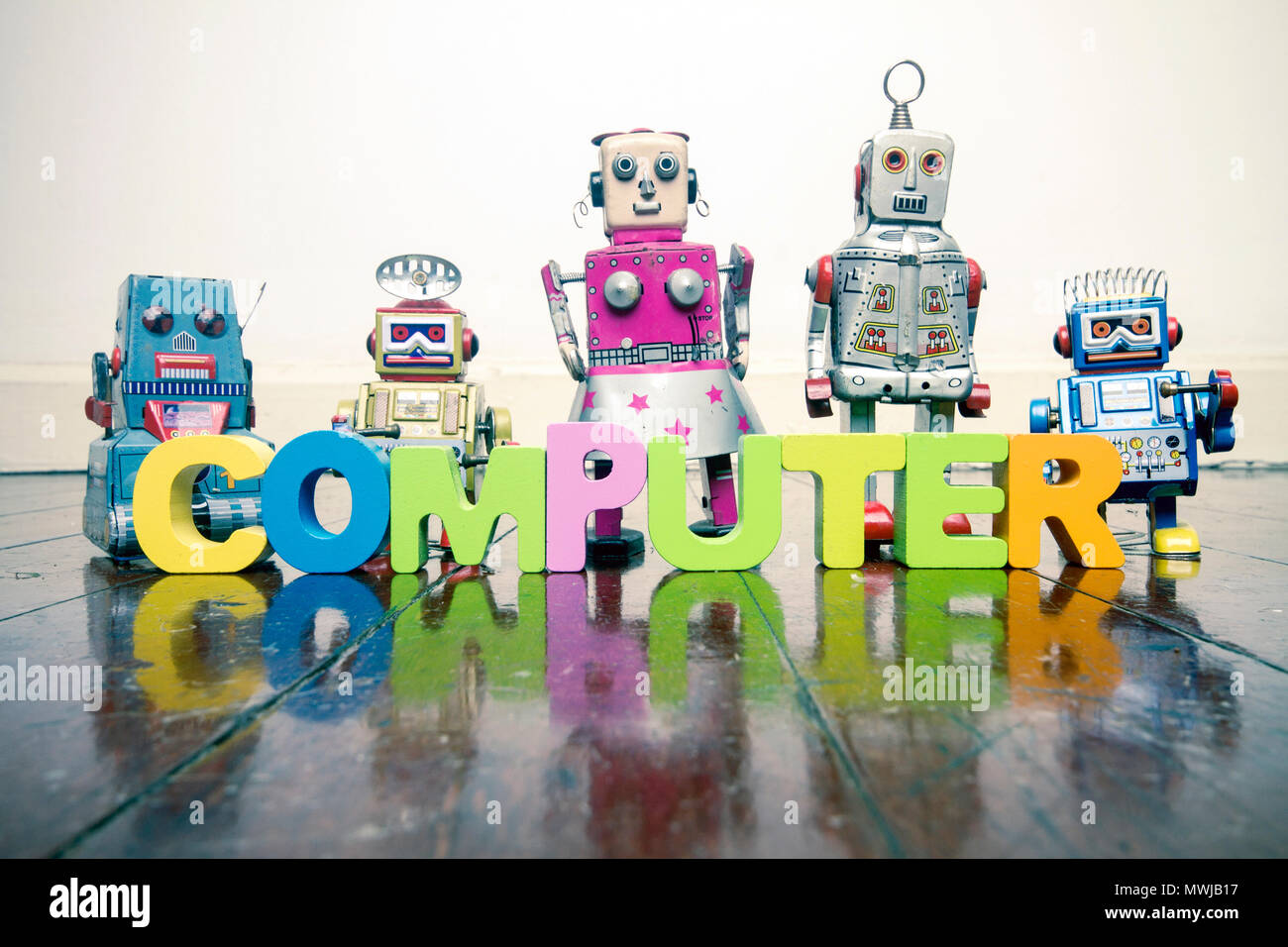 the word COMPUTER with wooden letters and retro toy robots on an old ...