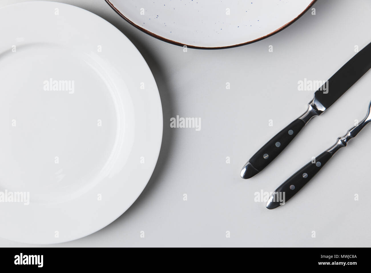 Two different plates with cutlery, table appointments conception Stock ...