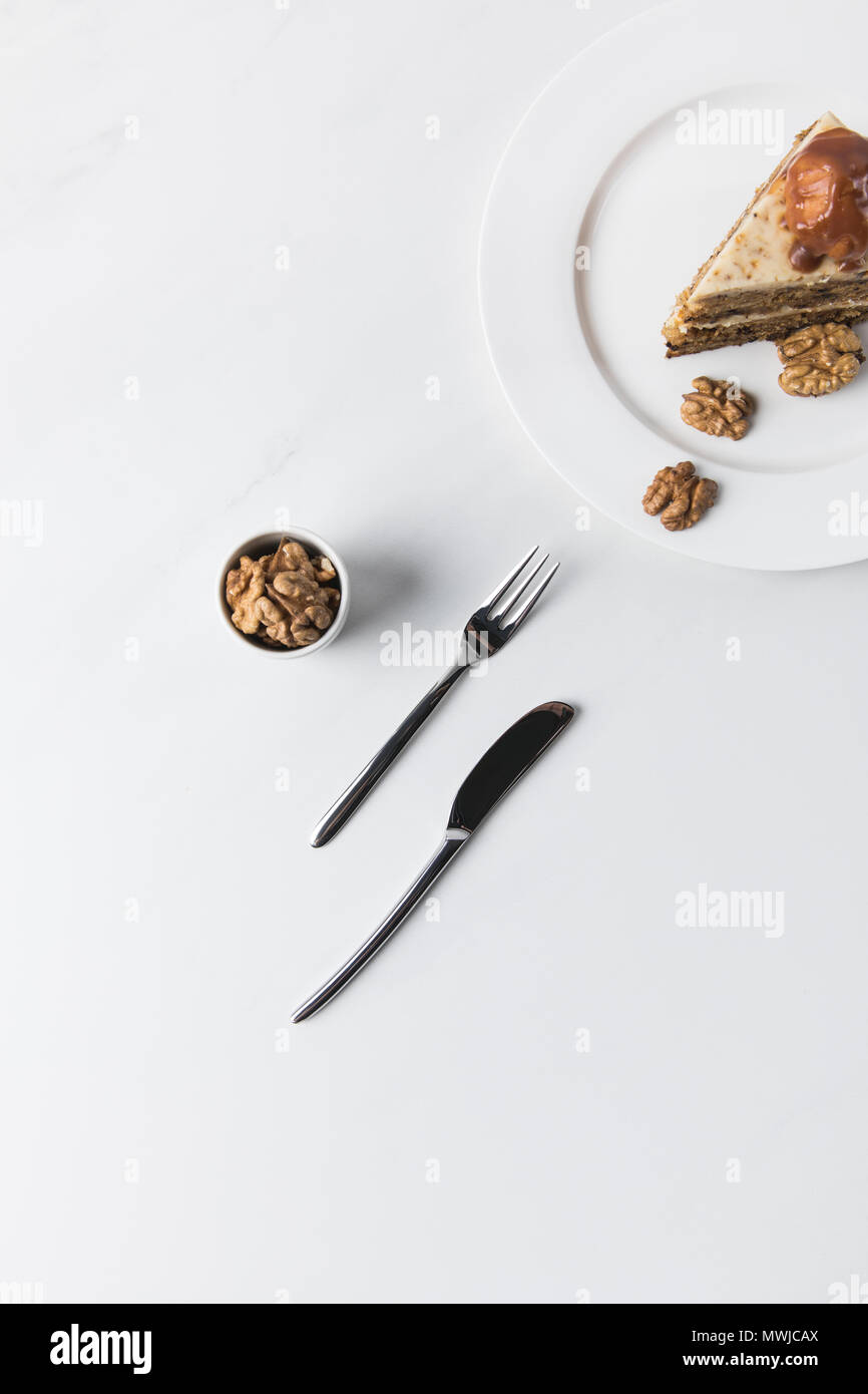 Top view of cake on plate, walnuts and cutlery Stock Photo - Alamy