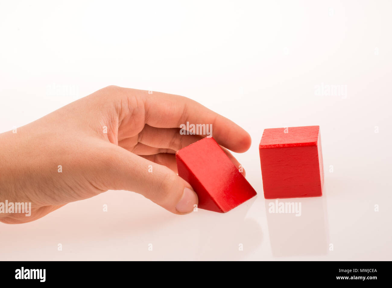 Hand playing with colorful cubes on a white background Stock Photo - Alamy