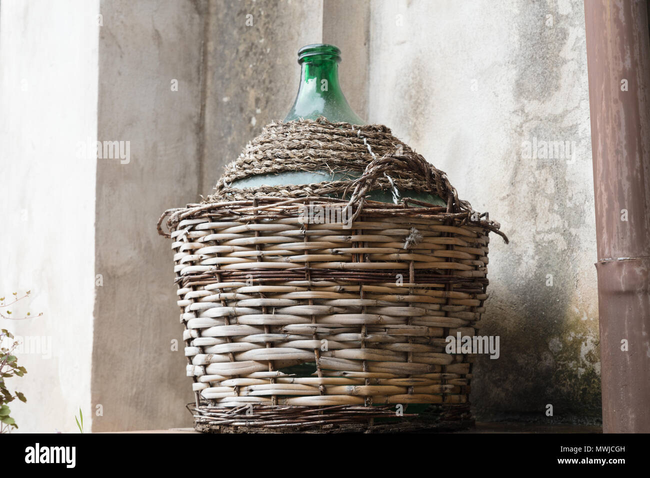 Empty carboy in rustic house, leaning against the wall Stock Photo - Alamy