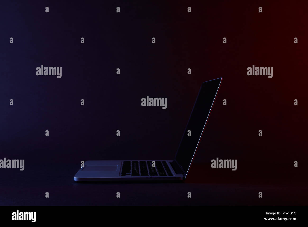 one open laptop with reflecting screen on dark surface Stock Photo - Alamy