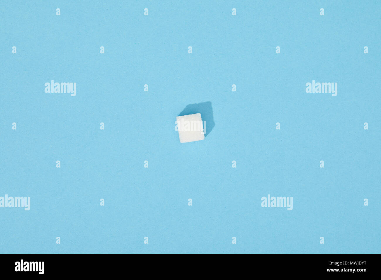 sweet white sugar cube with shadow on blue Stock Photo - Alamy