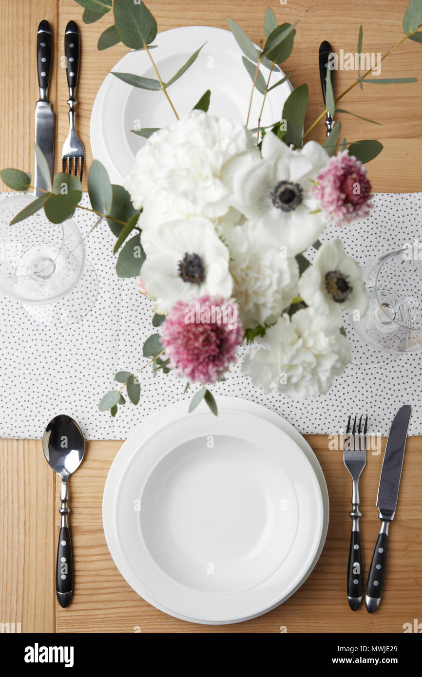 Festive table with cutlery and plates on table with flowers Stock Photo ...