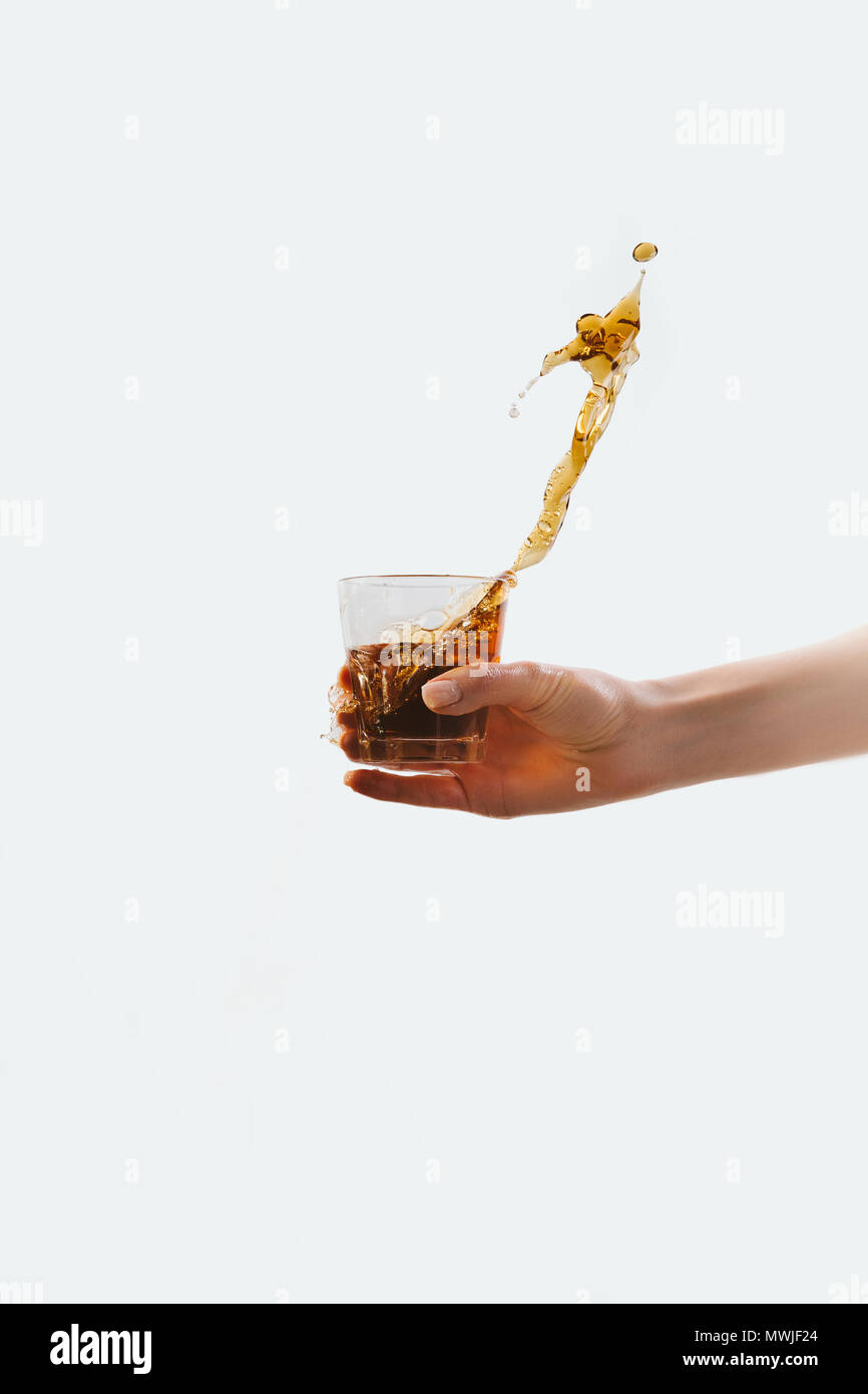 cropped view of hand holding glass with splash of coffee, isolated on ...