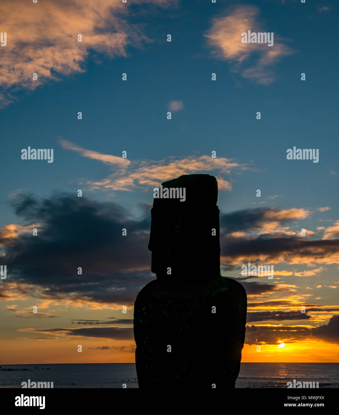 Dramatic colourful orange sunset at Tahai Moai, with stone Moai figure ...