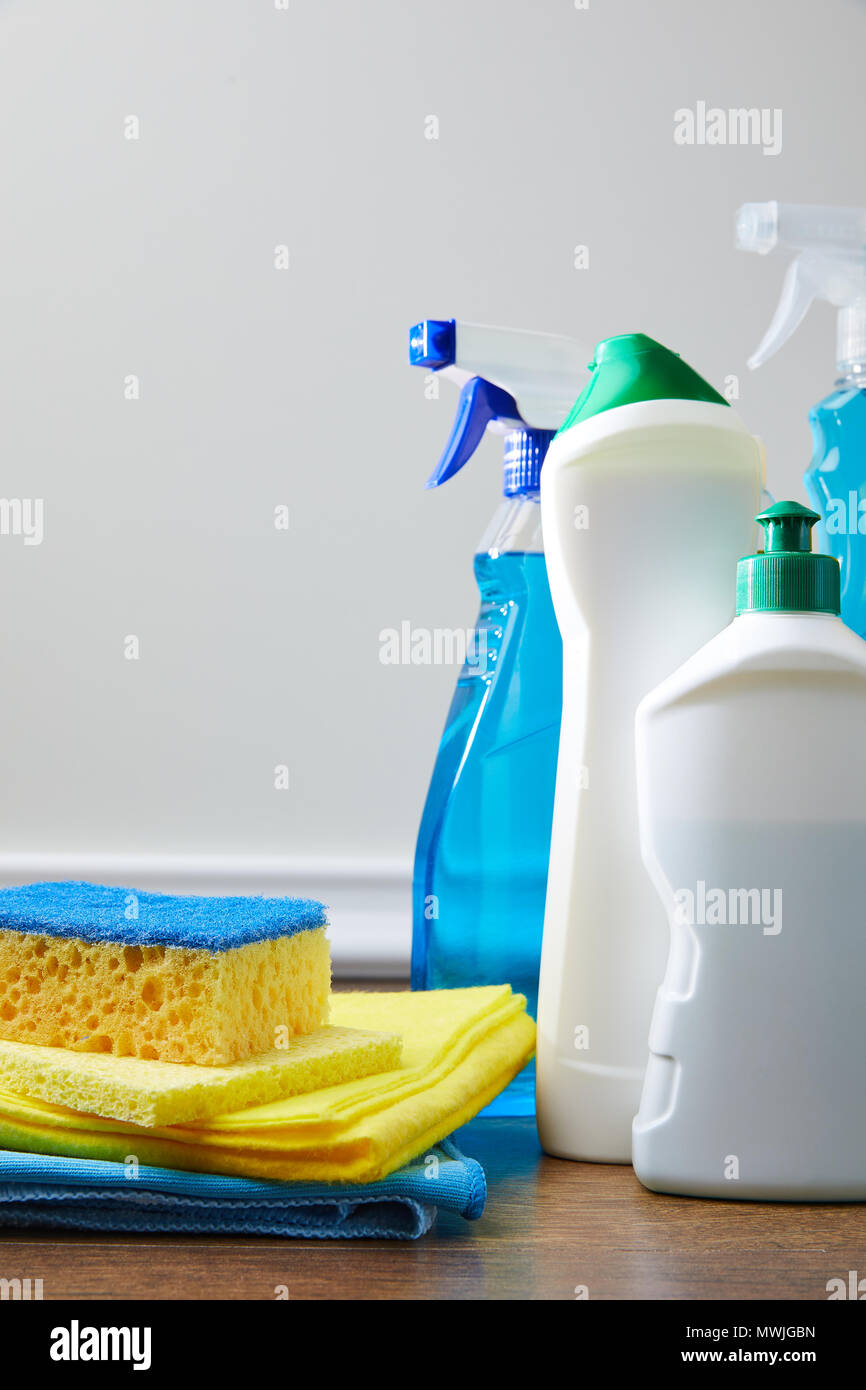 blue and yellow sponge, rags and bottles for spring cleaning on floor ...
