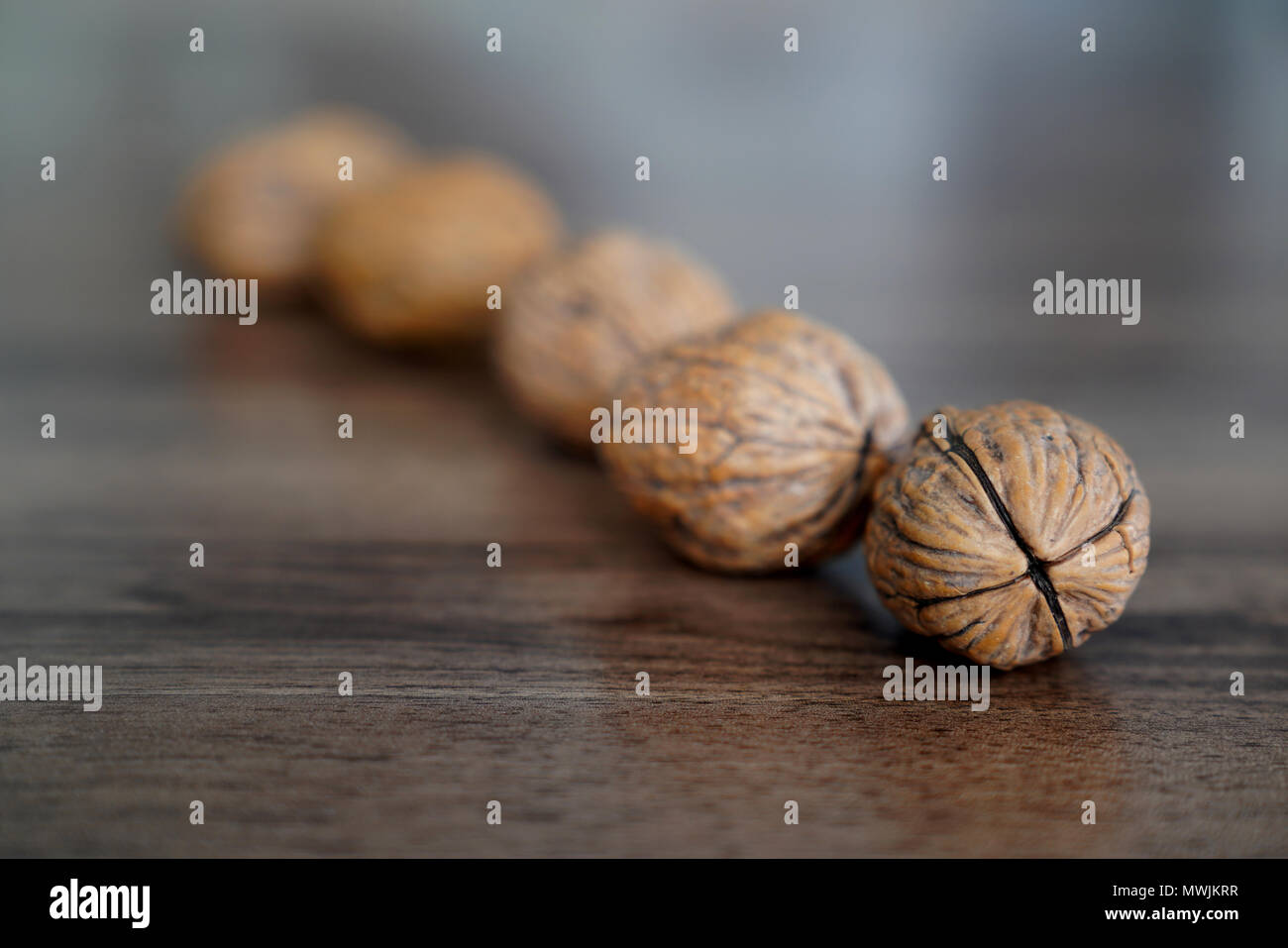 Five walnuts in a row crossed on dark walnut table background Stock ...