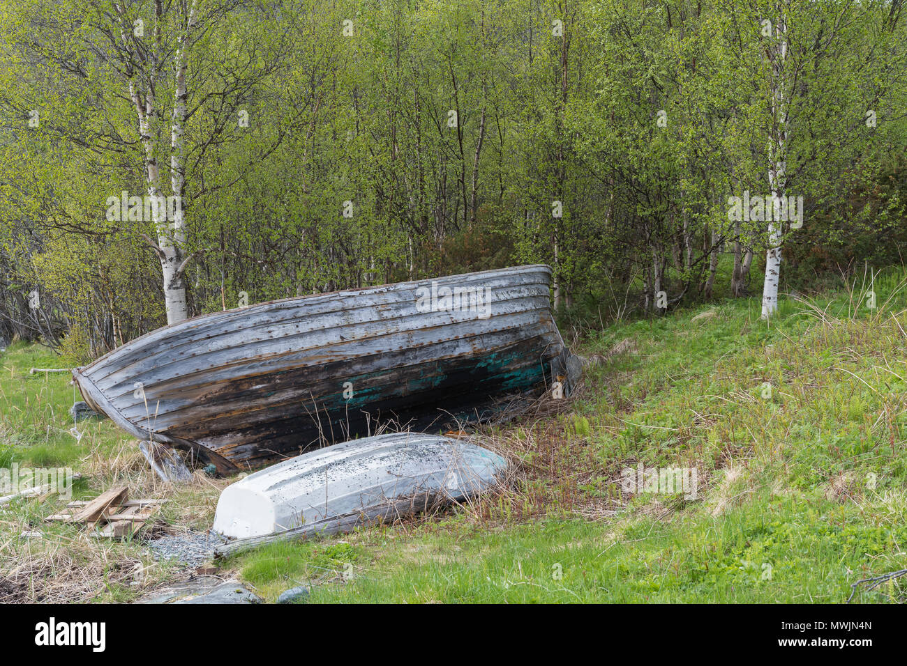 Old retired boat at shore with small boat dinghy Stock Photo - Alamy
