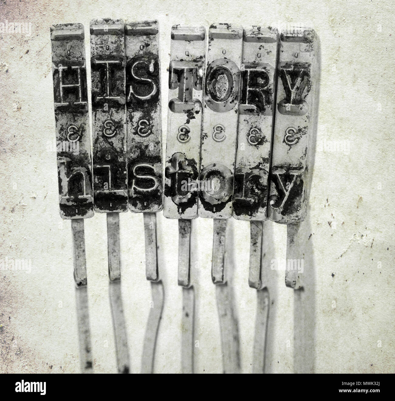 The word HISTORY with old typewriter hammers with old paper background ...