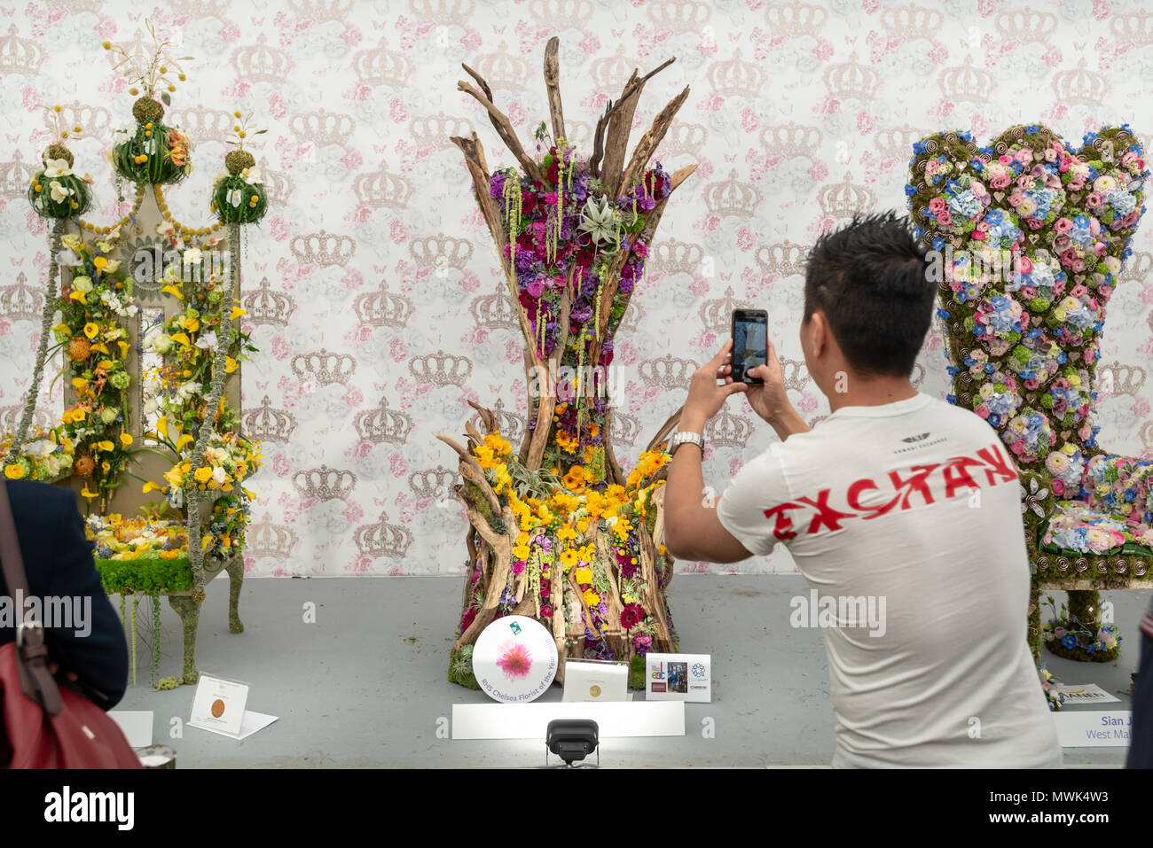A visitor to the RHS Chelsea Flower Show in London, UK takes a ...