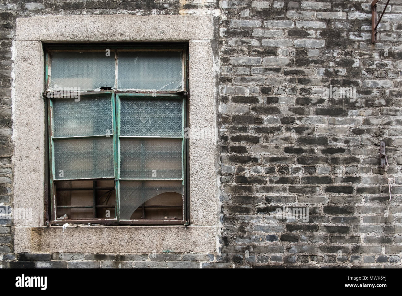 Old rough gray bricks wall with dirty broken glass window. Building ...
