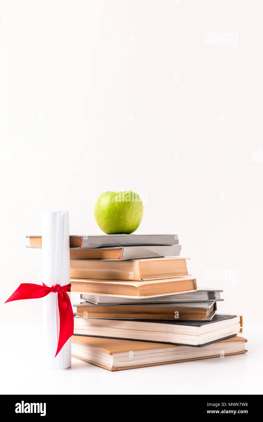Diploma with stack of books with apple on top isolated on white Stock ...