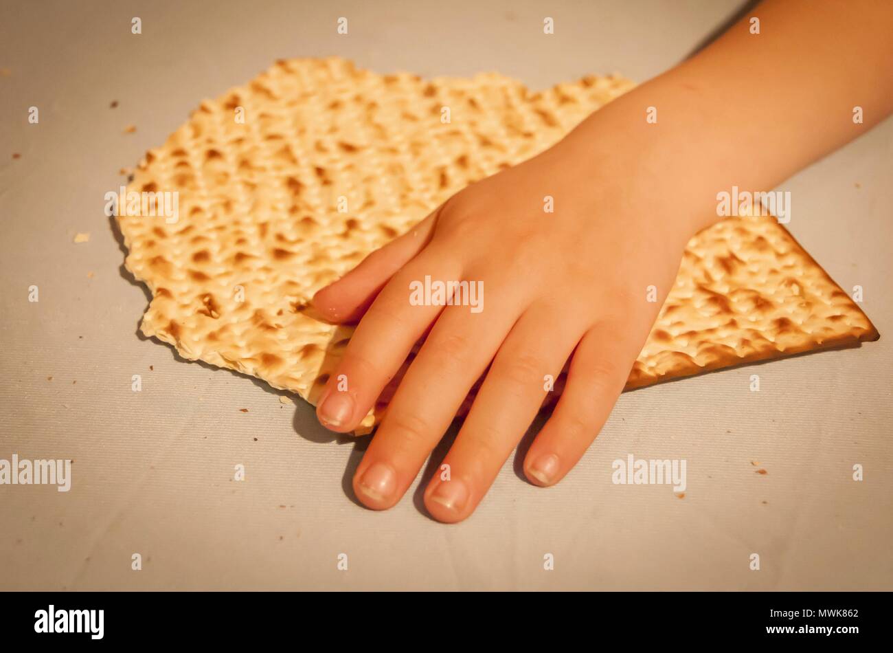 A hand of a child on the matzah as a symbol of tradition passing from ...