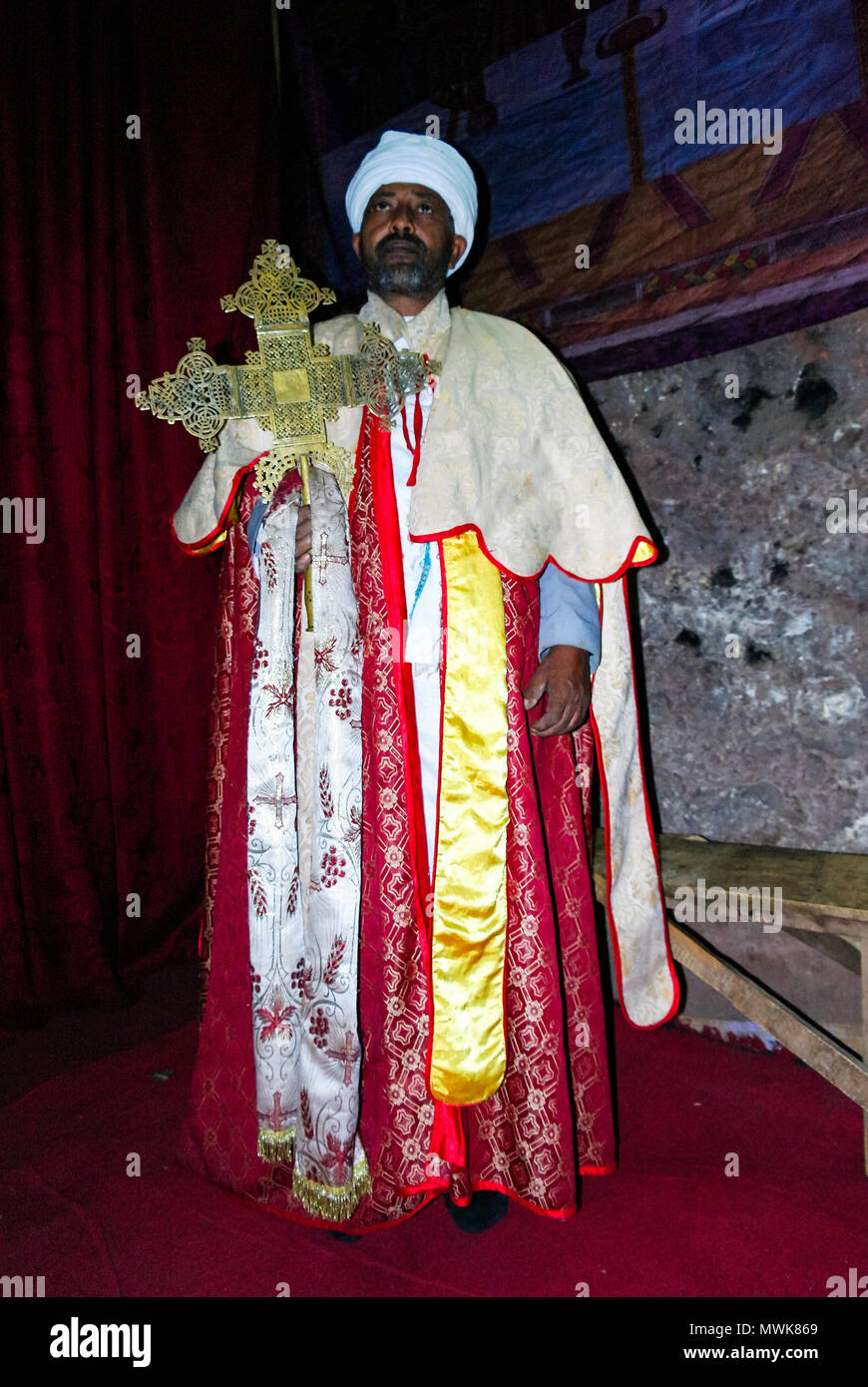 portrait of coptic orthodox christian priest with big cross inside rock ...
