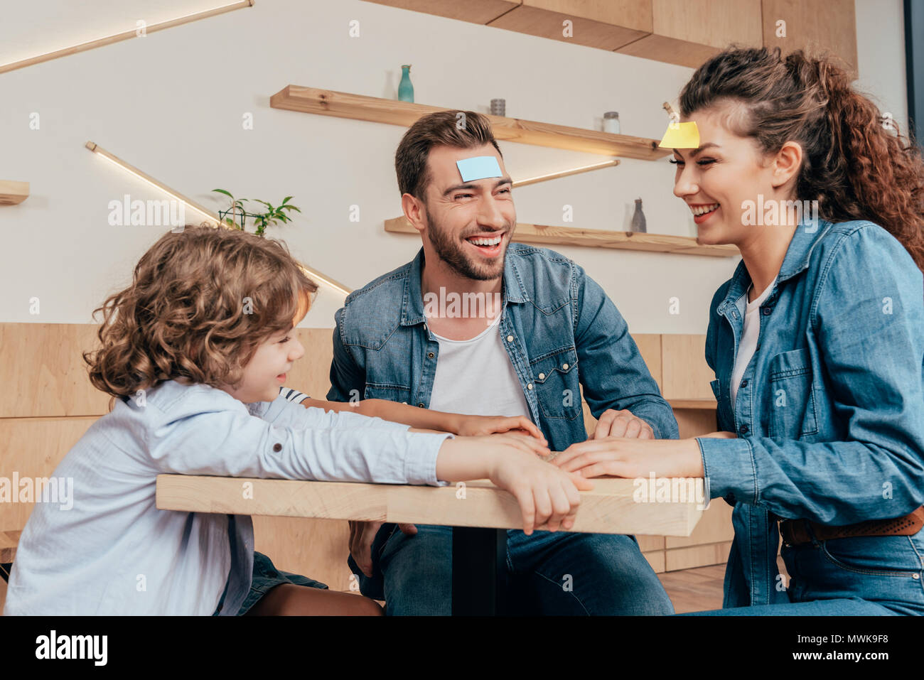 happy young family playing guess sticker Stock Photo - Alamy