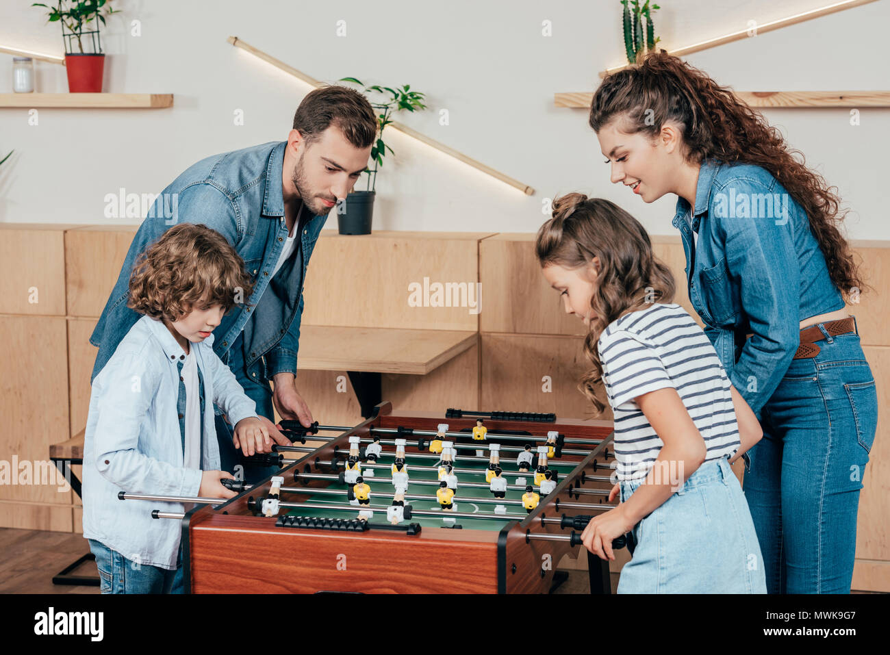 beautiful young family family playing table football in cafe Stock ...