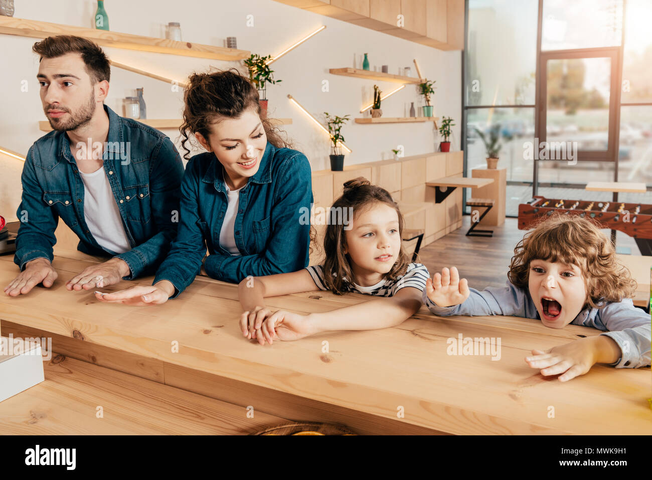 beautiful young family in restaurant at bar counter Stock Photo - Alamy