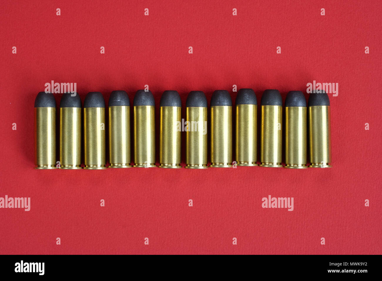 The .45 caliber revolver cartridges on red background Stock Photo - Alamy